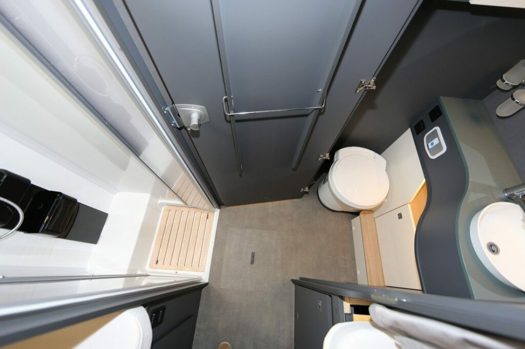 Salon face-face et salle d’eau transversale dans le camping-car, le duo ...