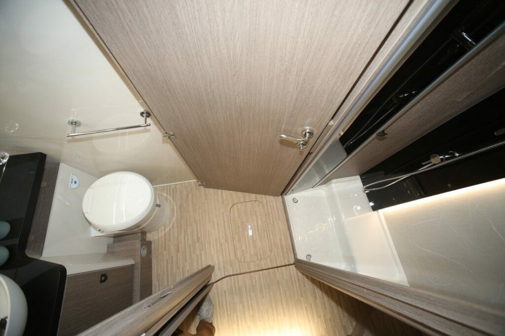 Salon face-face et salle d’eau transversale dans le camping-car, le duo ...